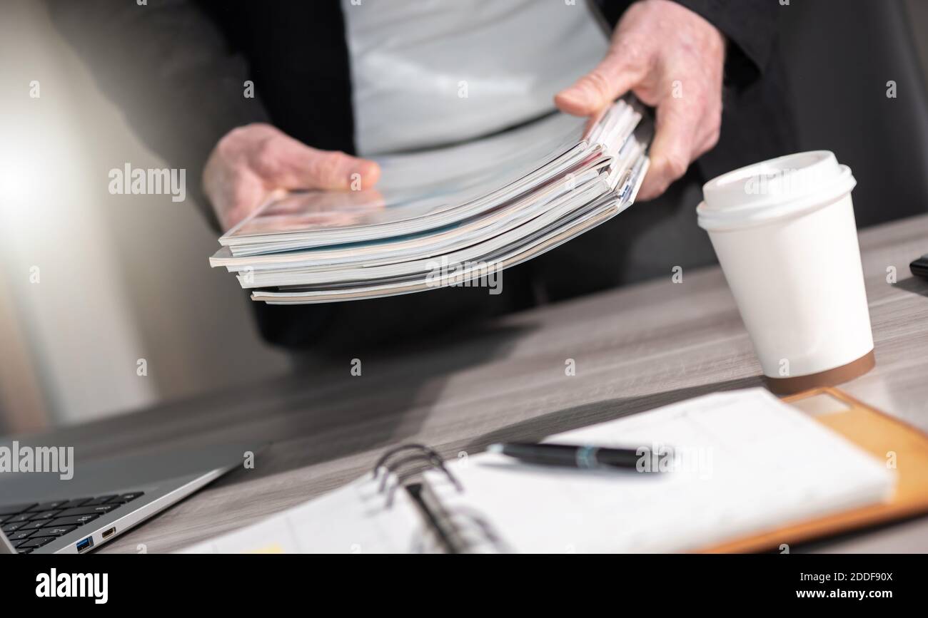Male hands holding a stack of magazines Stock Photo - Alamy