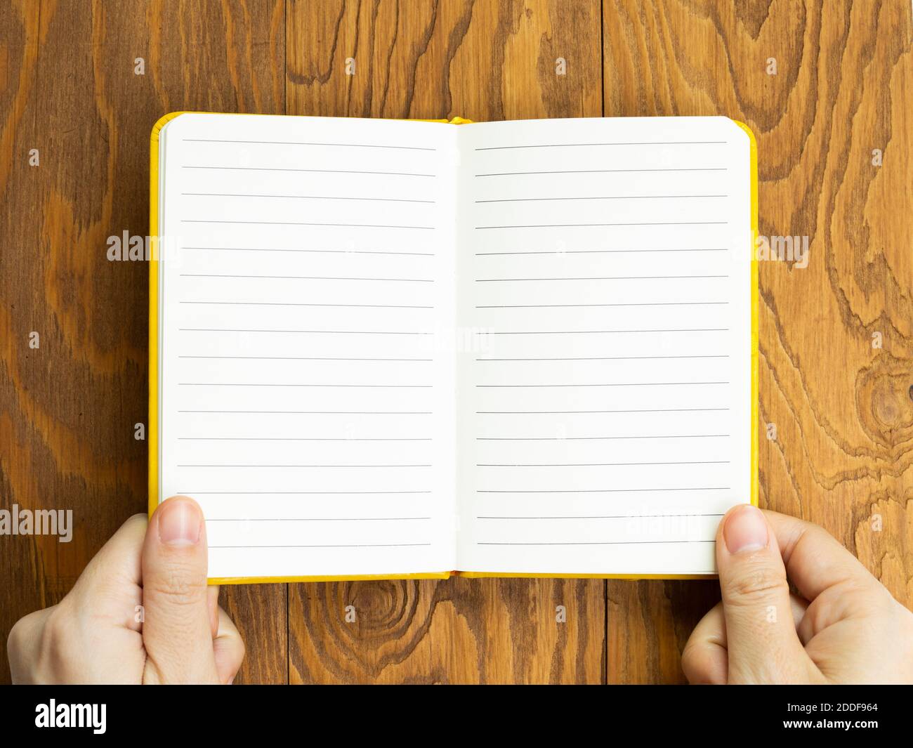 Hands open empty notebook on wooden desk. top view, copy space Stock Photo - Alamy
