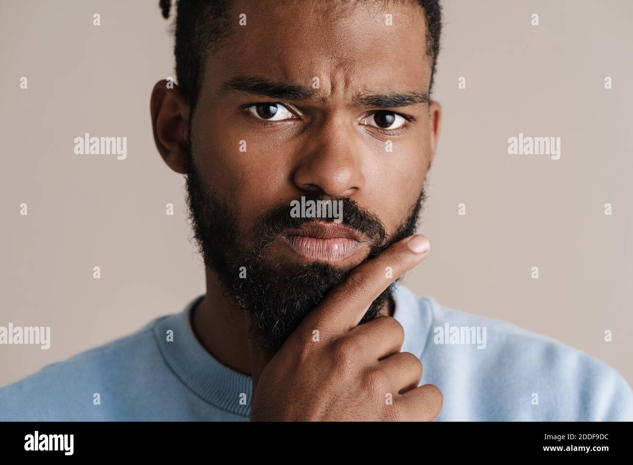 Brooding african american guy posing and looking at camera isolated ...