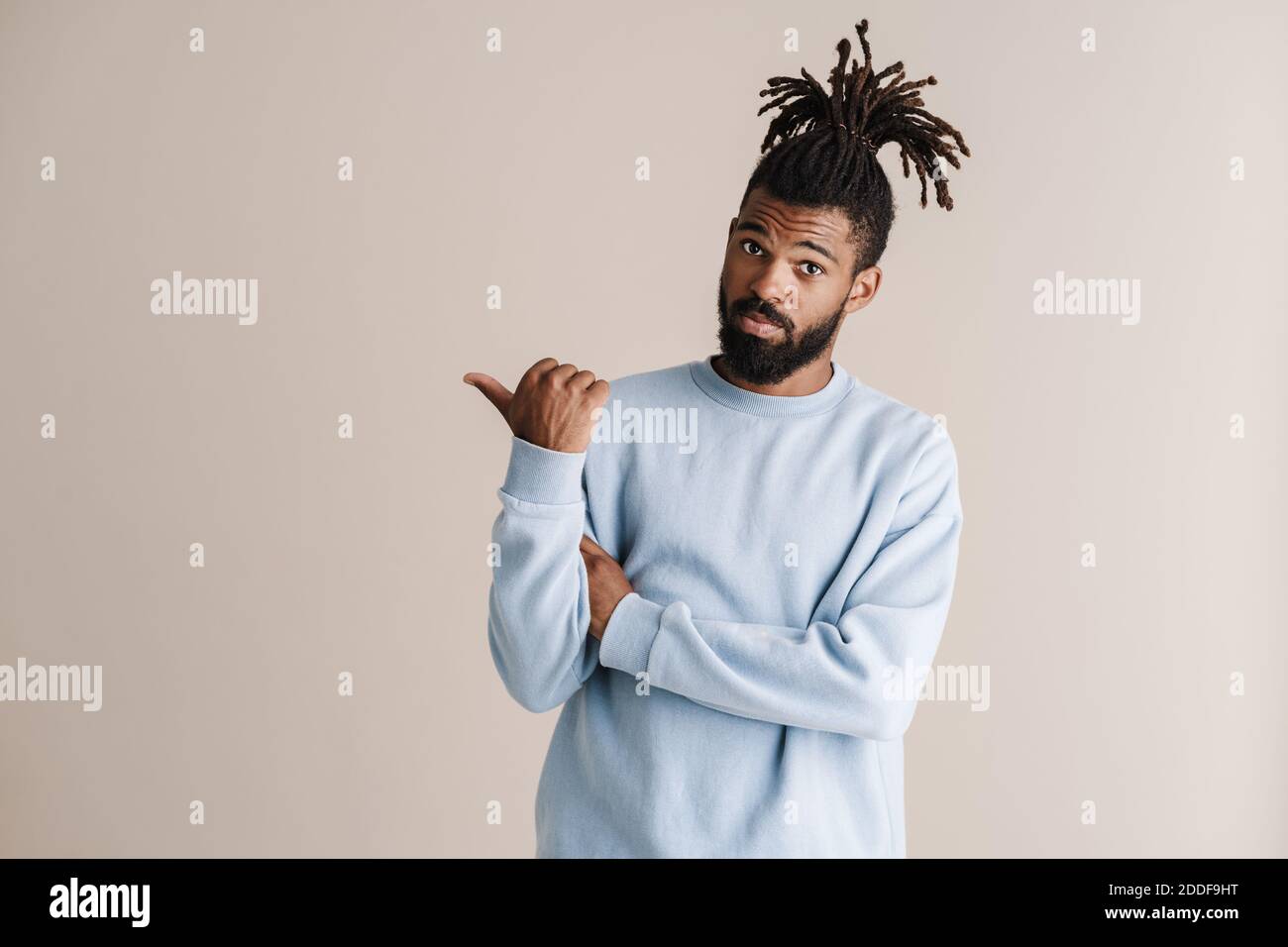 Confused african american guy pointing finger aside isolated over white ...