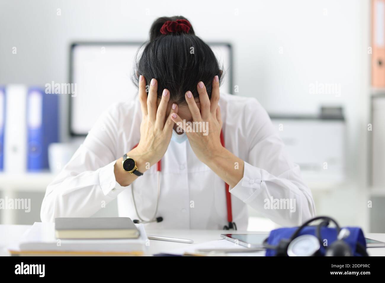 Tired doctor bowing his head in office after working day Stock Photo ...