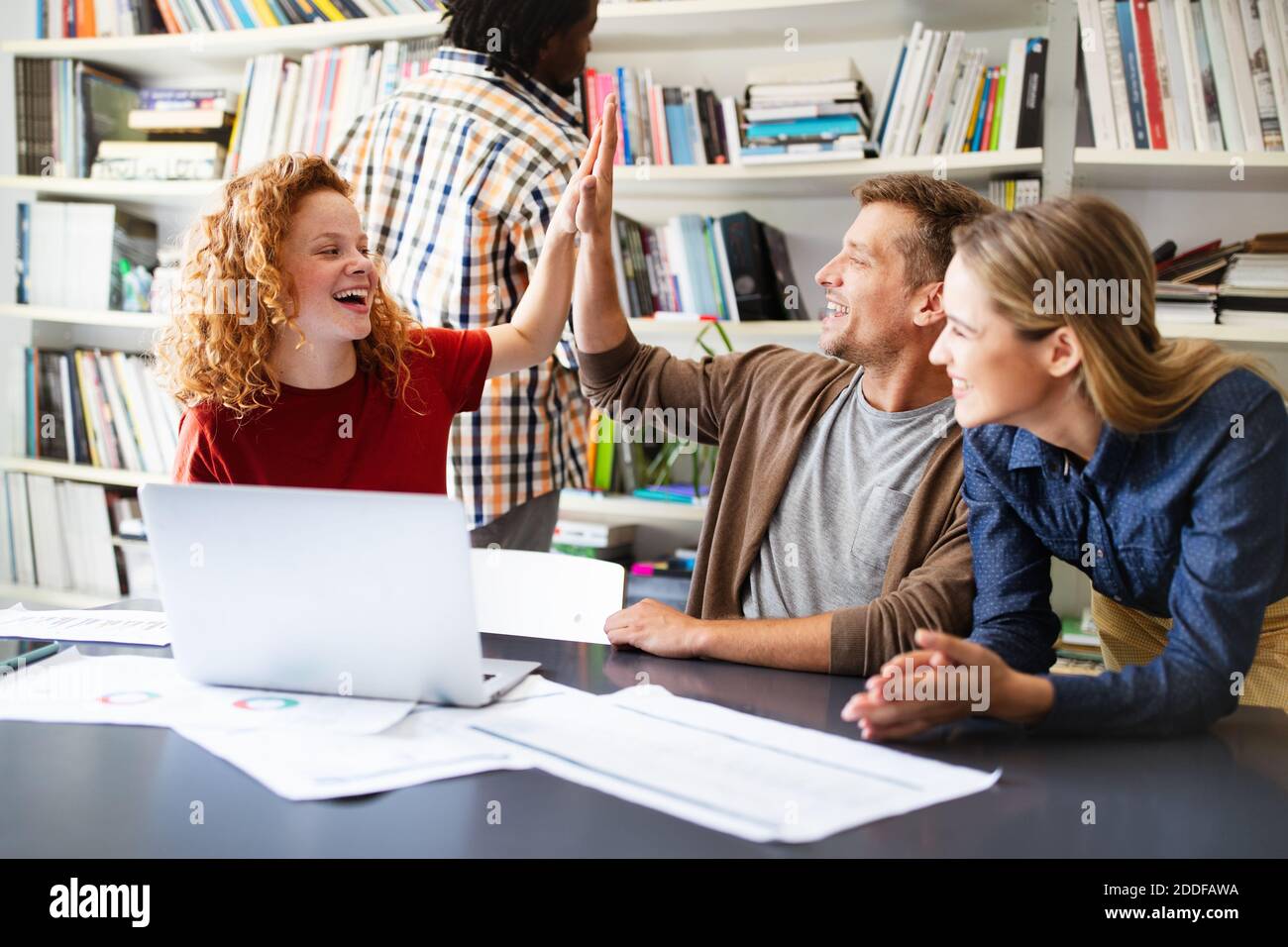 Happy business people celebrating success at company Stock Photo - Alamy