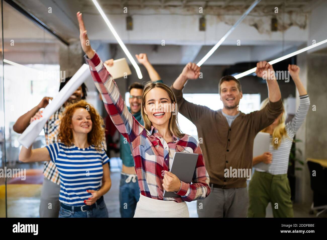 Happy business people celebrating success at company Stock Photo - Alamy