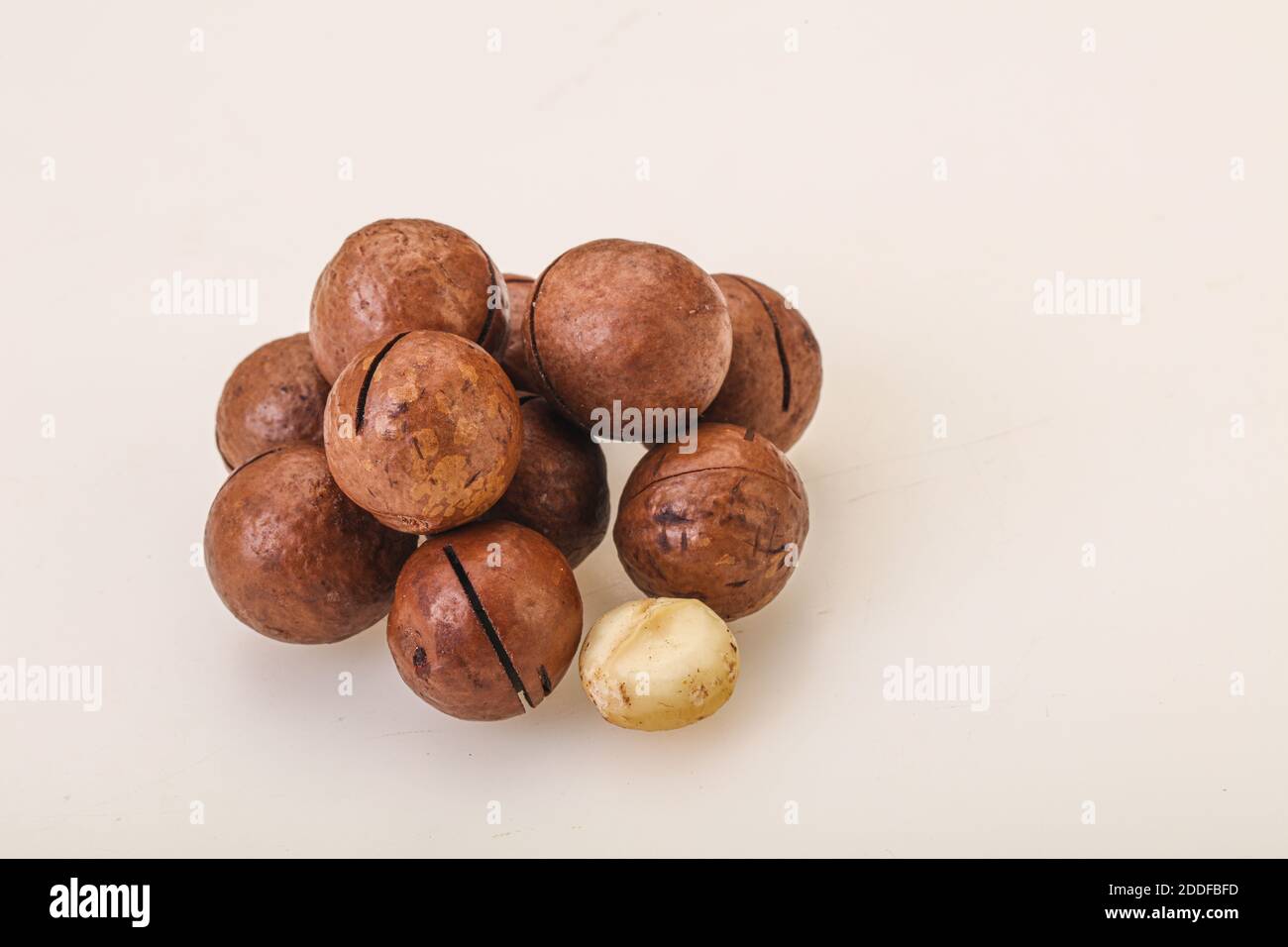 Brown closeup macadamia nut heap over background Stock Photo - Alamy