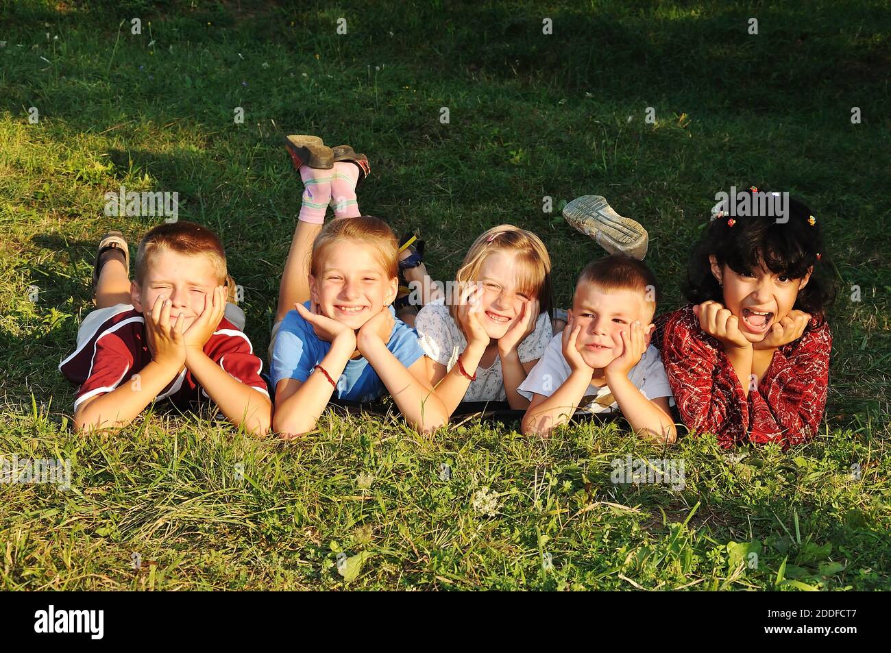 Happy beautiful children laying on ground outdoor Stock Photo - Alamy