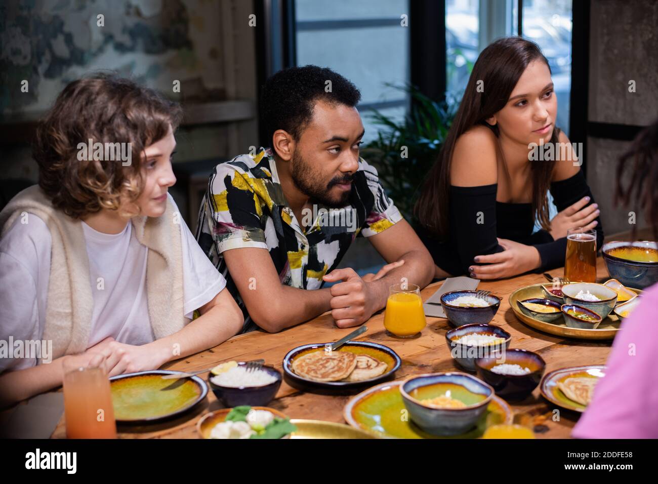 Friends eating and tasting food in a modern asian style cafe Stock ...