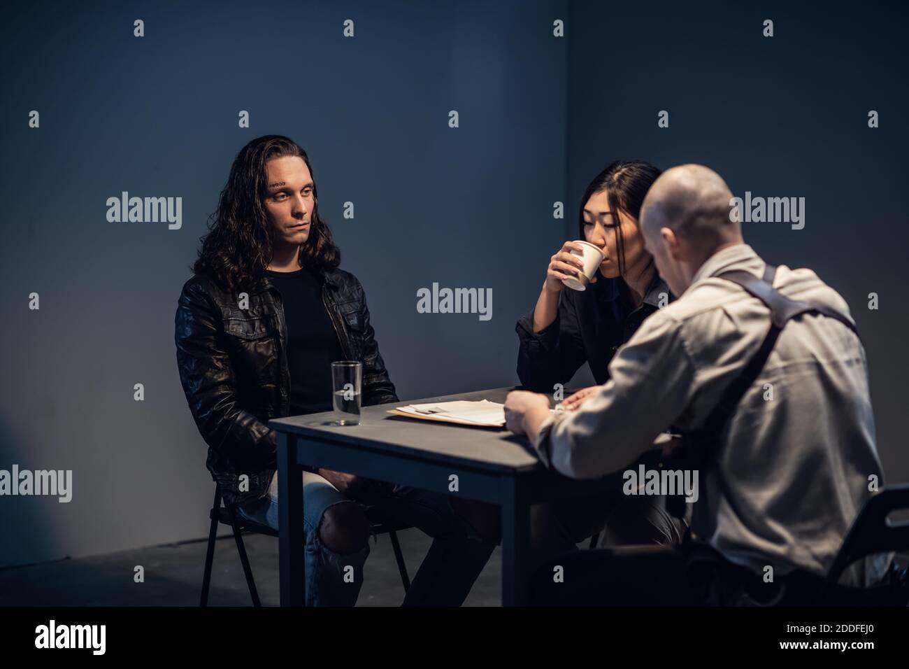 In the interrogation room, the investigator shows the suspect evidence ...