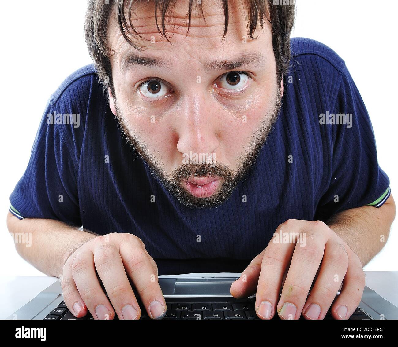 Young man with beard and expression on his face in front of laptop ...