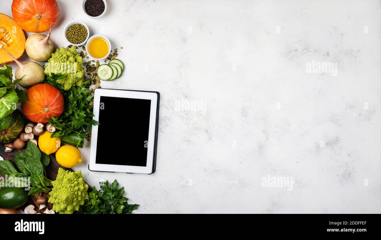 Tablet computer with blank screen Different vegetables and greens. Top ...
