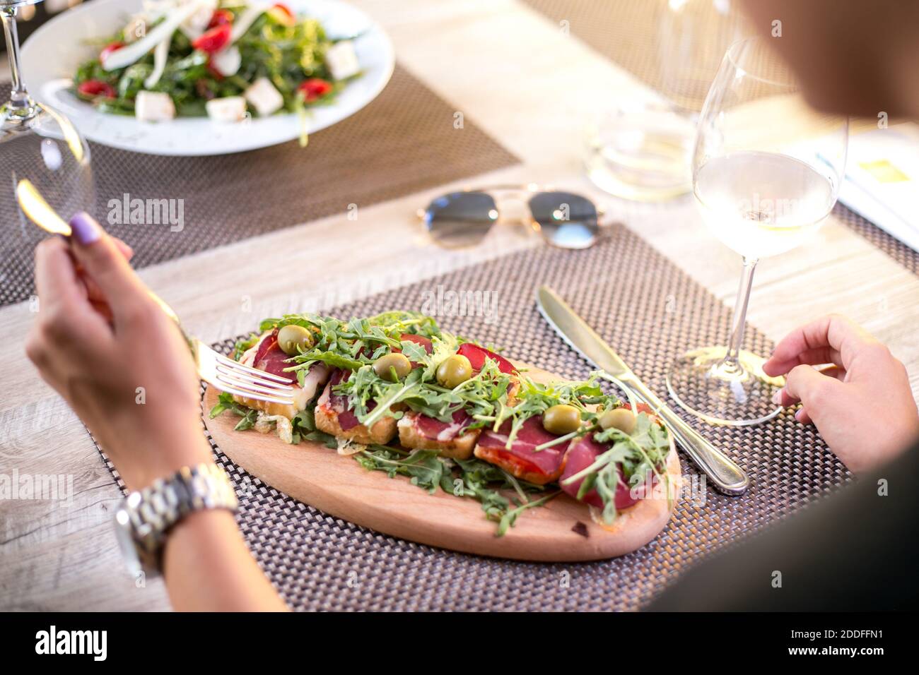 A high angle shot of a woman eating an appetizer plate in a restaurant ...