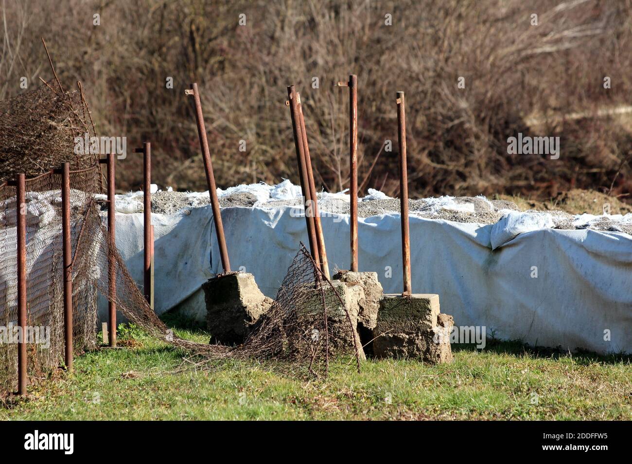 Bunch of completely rusted metal poles with concrete foundation left ...