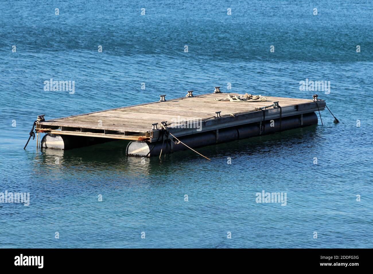 Elongated homemade makeshift old floating pier made from empty metal ...