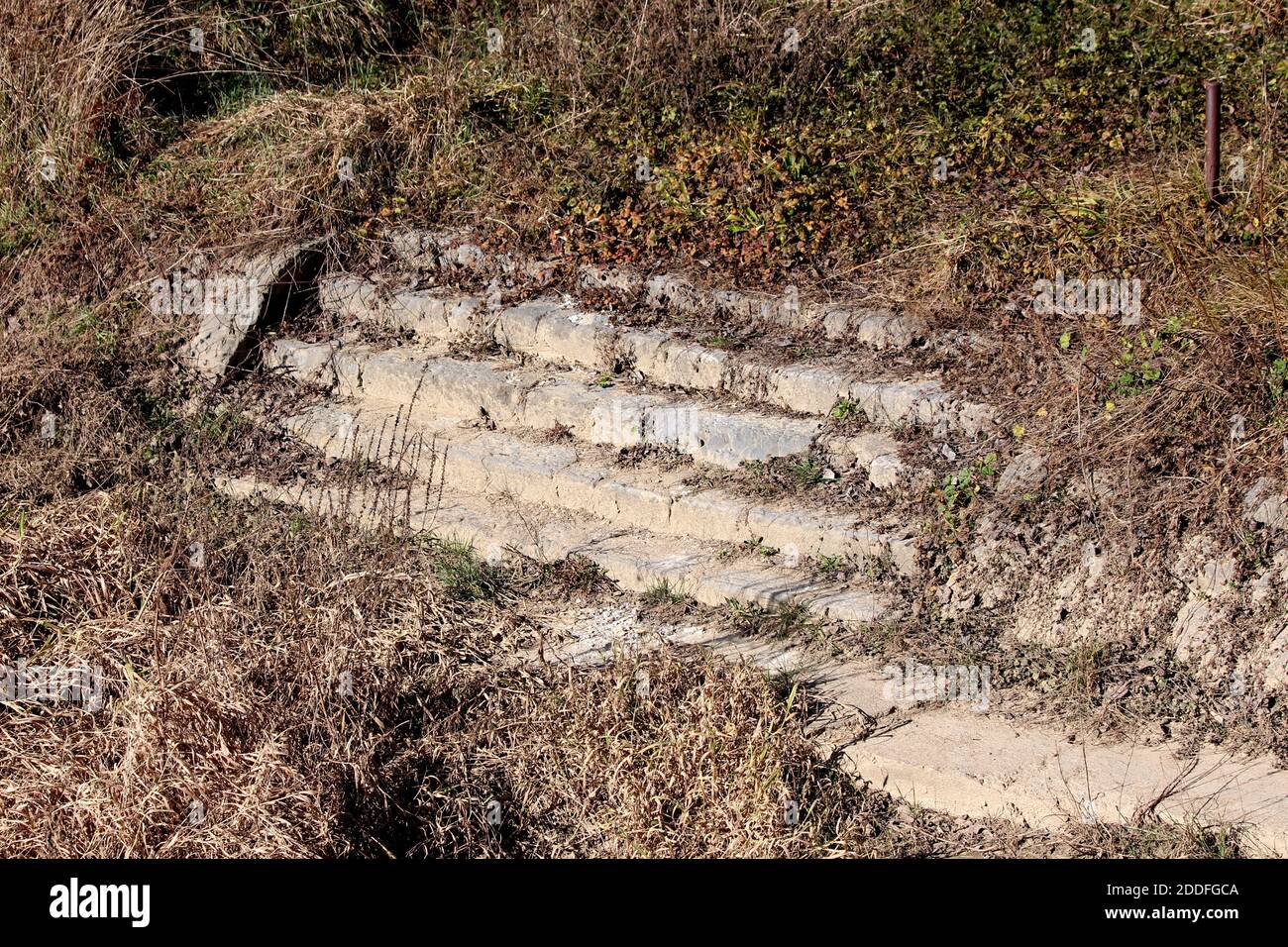 Old outdoor stairs made from stone and concrete on side of river bank ...