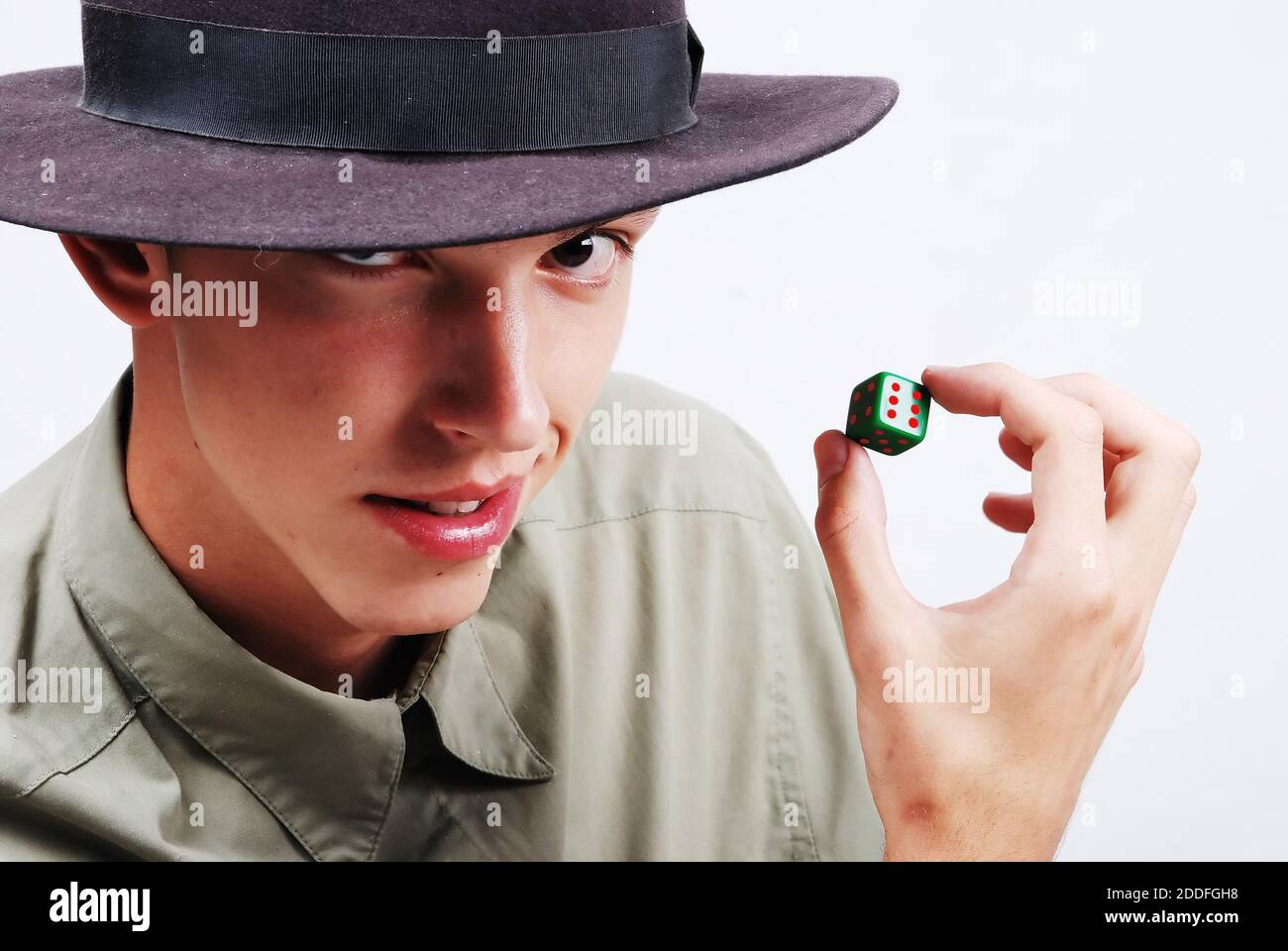 Young male holding gamble cube in hand with expression on his face ...