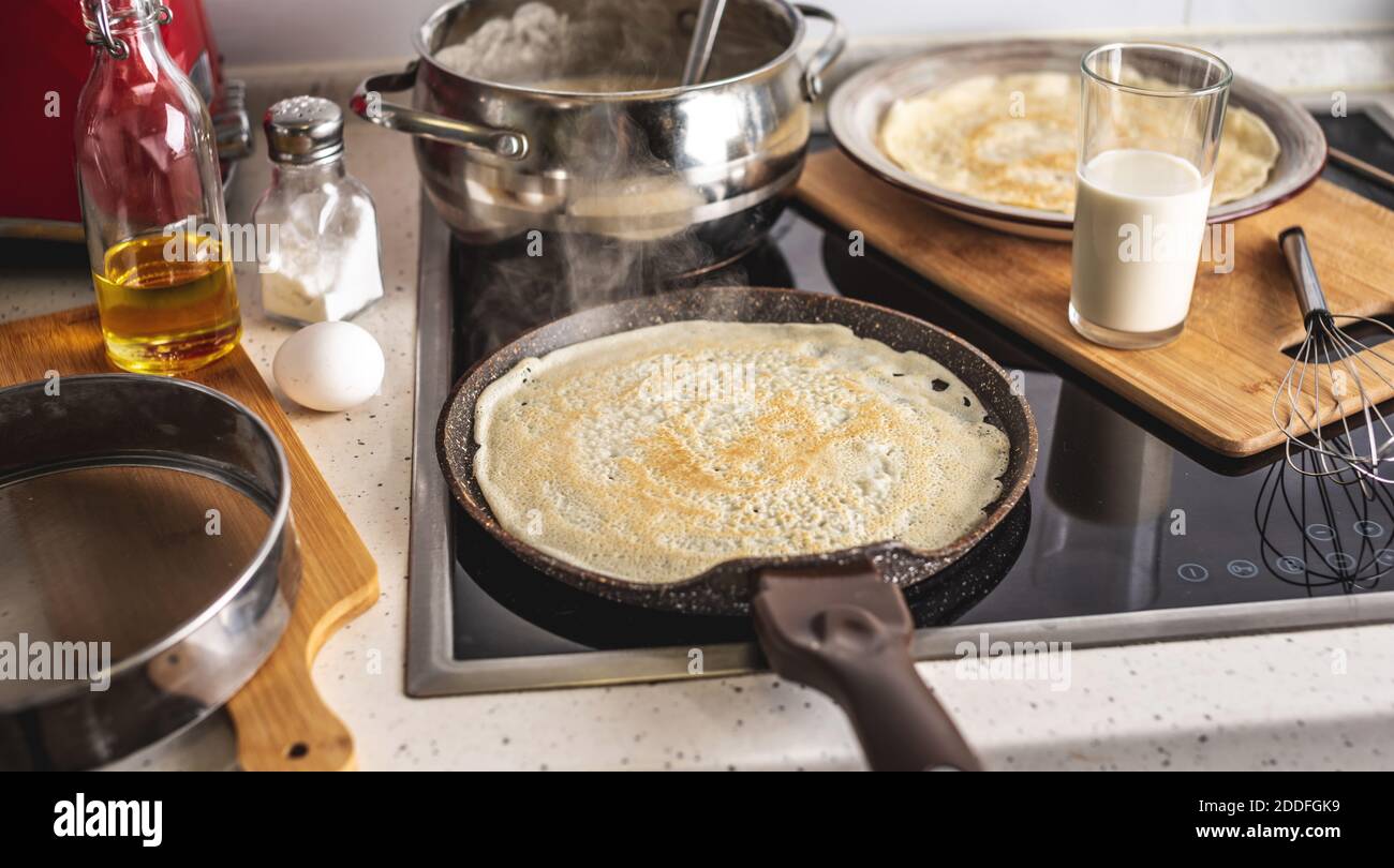 Delicious pancake is cooking in a hot frying pan. Concept of the ...
