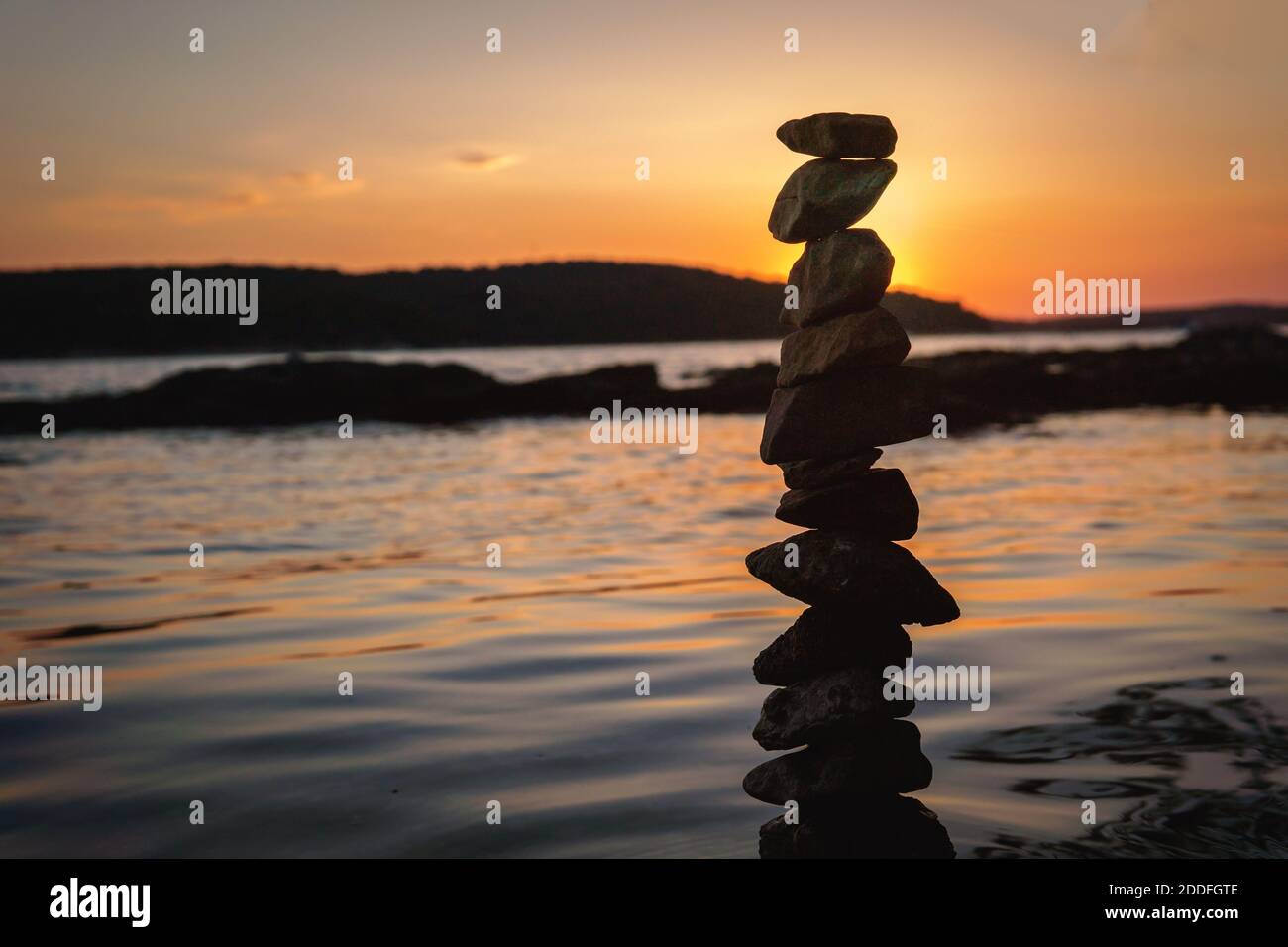 Zen balanced stones stacked on sea coast at sunset. Balance and ...