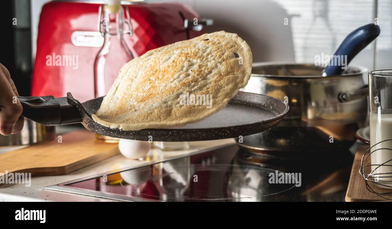Person is flipping the pancake over by throwing it. Concept of making ...