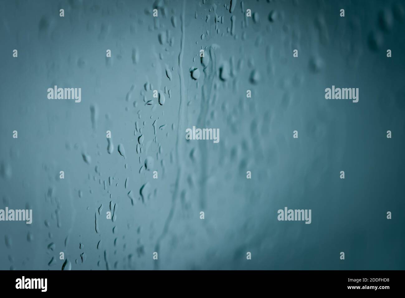 Close up of splashes of water and waterdrops running down on glass ...