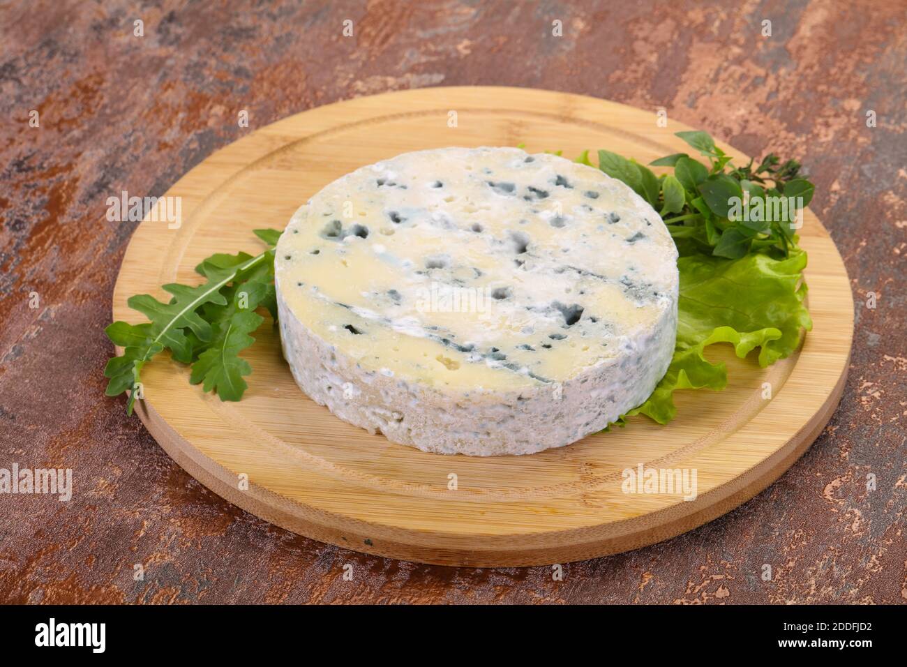 Round blue cheese with salad and basil Stock Photo - Alamy