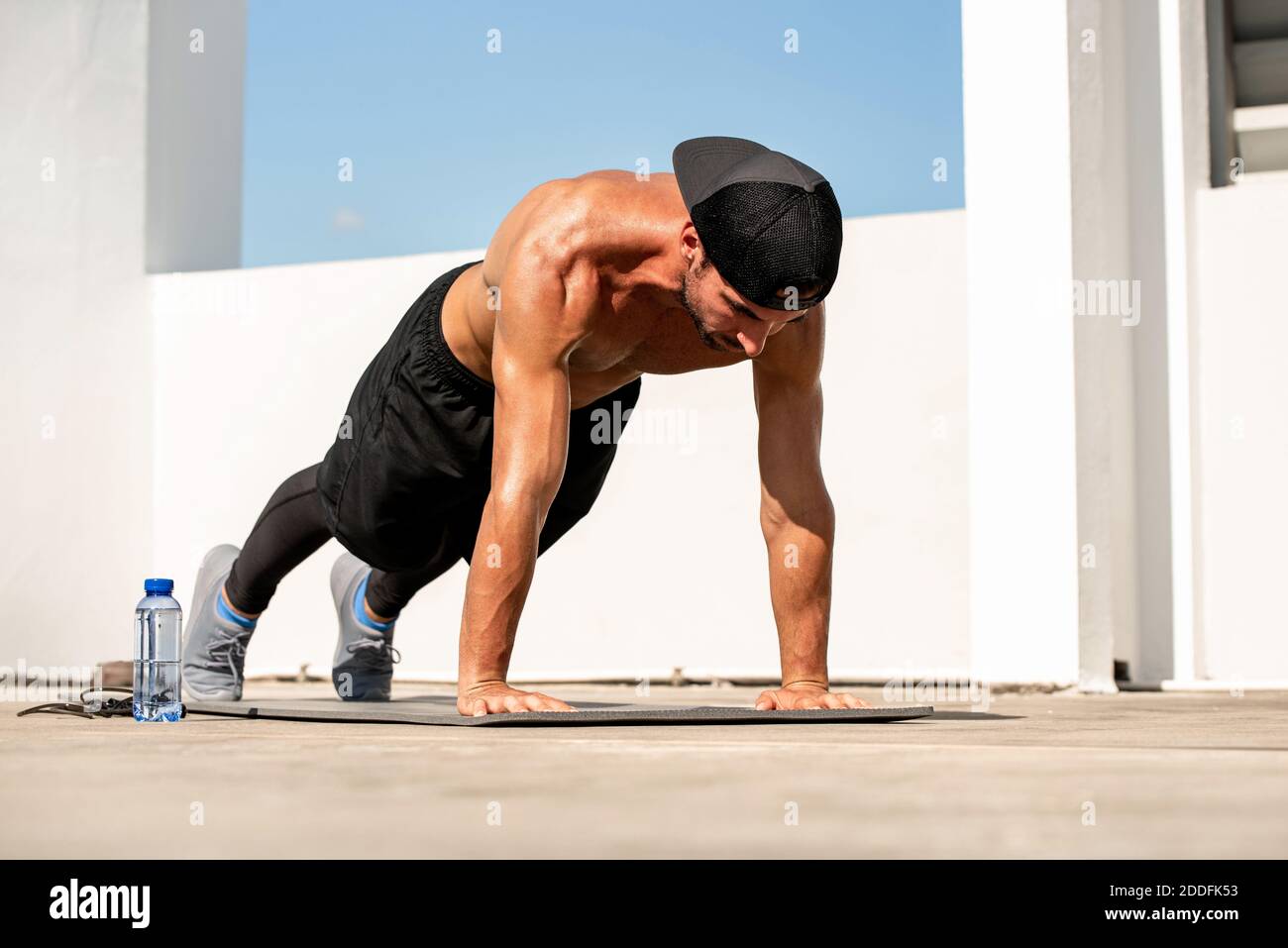 Fit sports man doing bodyweight push up exercise outdoors on building ...