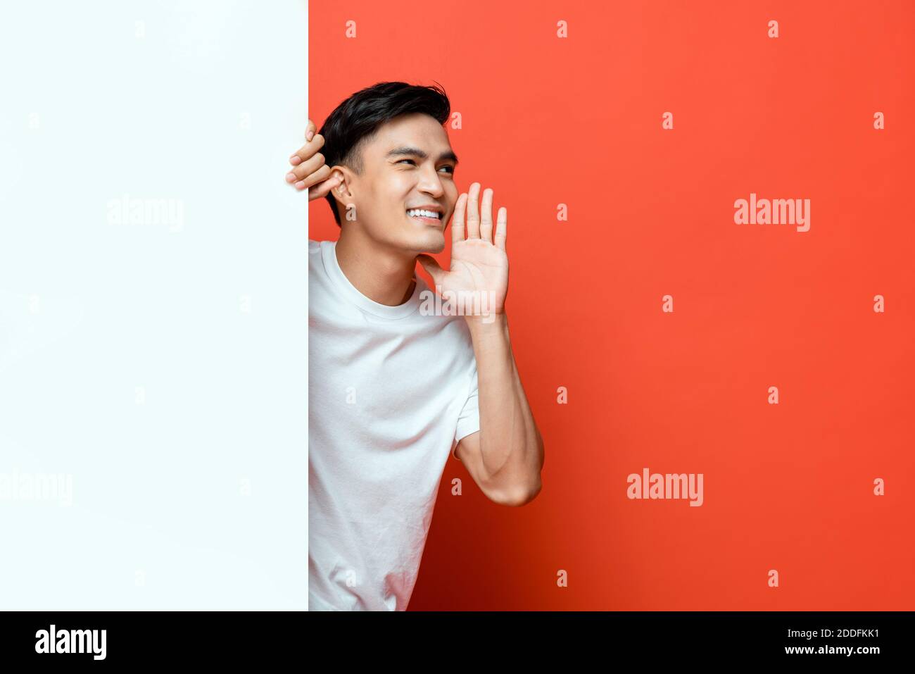 Smiling handsome Asian man about to say something with hand around ...