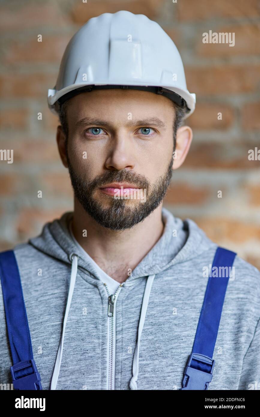 Close up portrait of confident attractive young male builder in hard ...