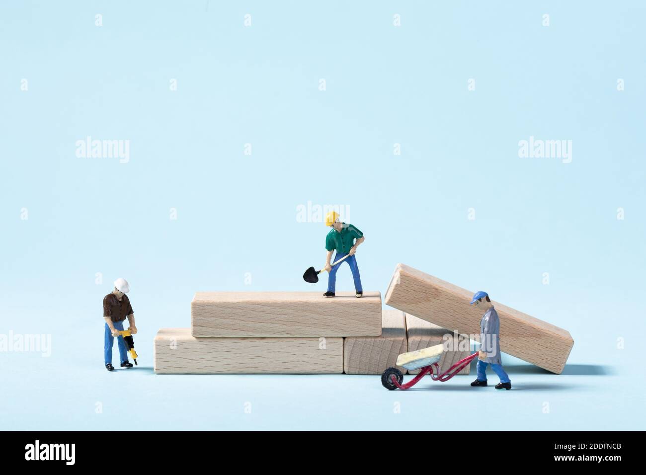 A closeup of toy construction workers doing their job on a blue ...