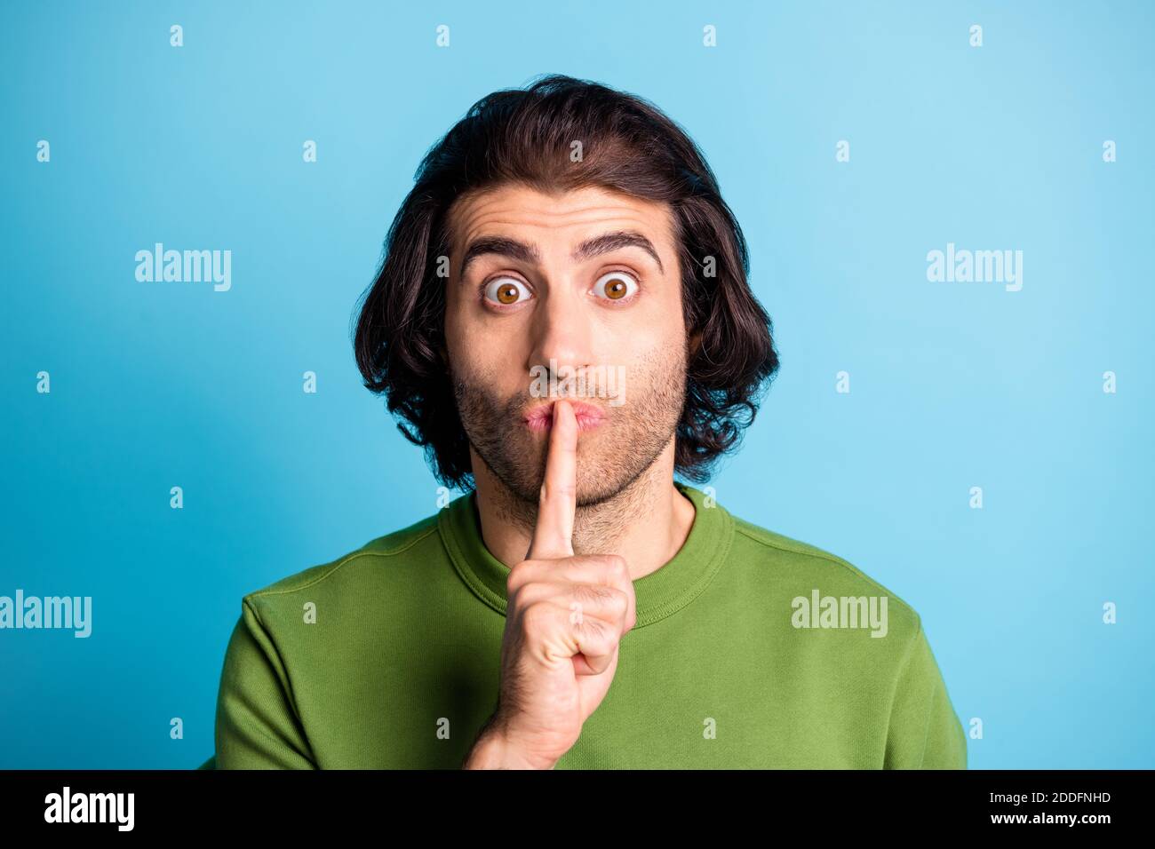 Close up portrait of confused young person show silent sign finger lips ...