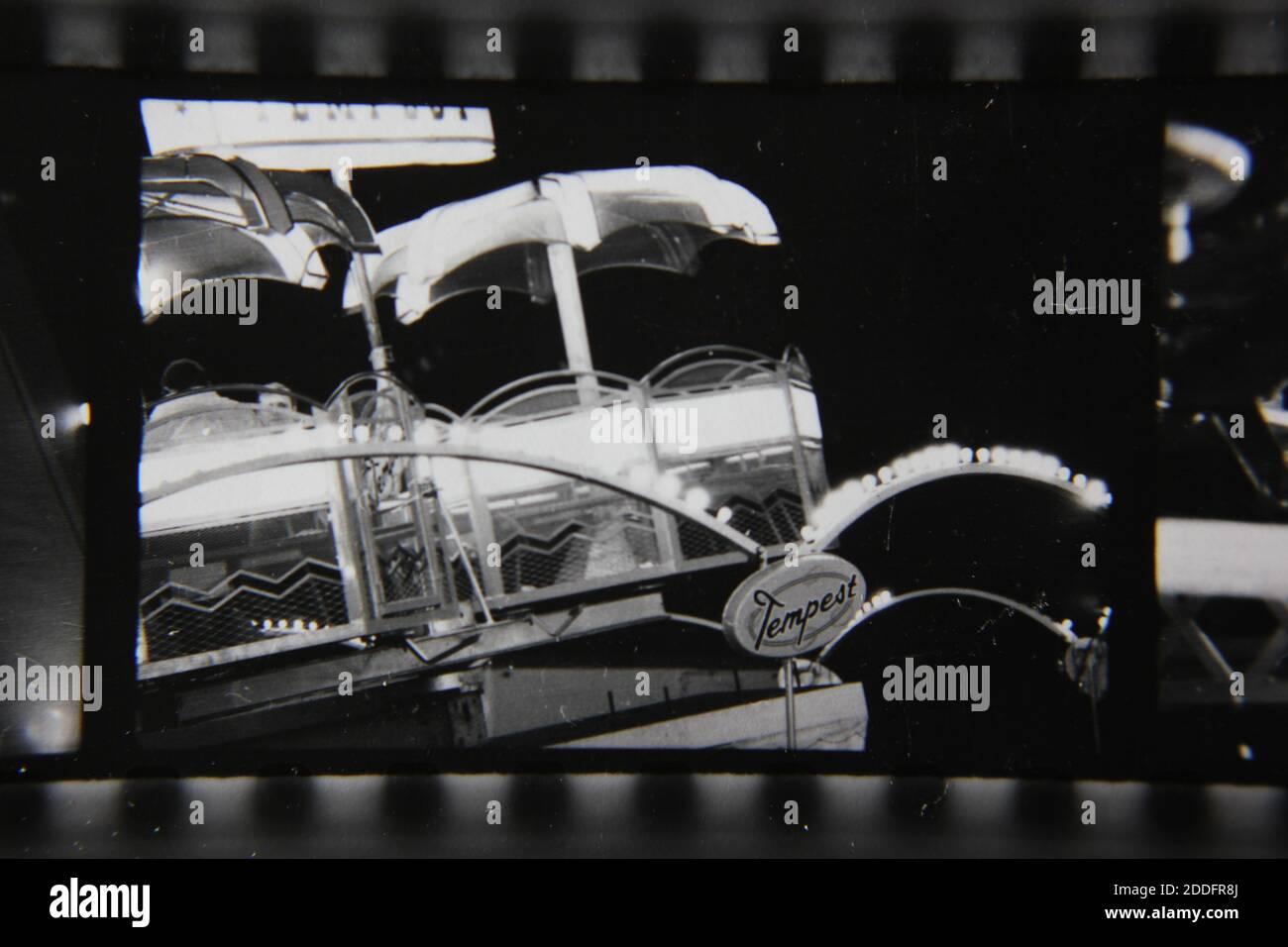 Fine 1970s vintage black and white photography of a carnival ride lit up at night with bright ...