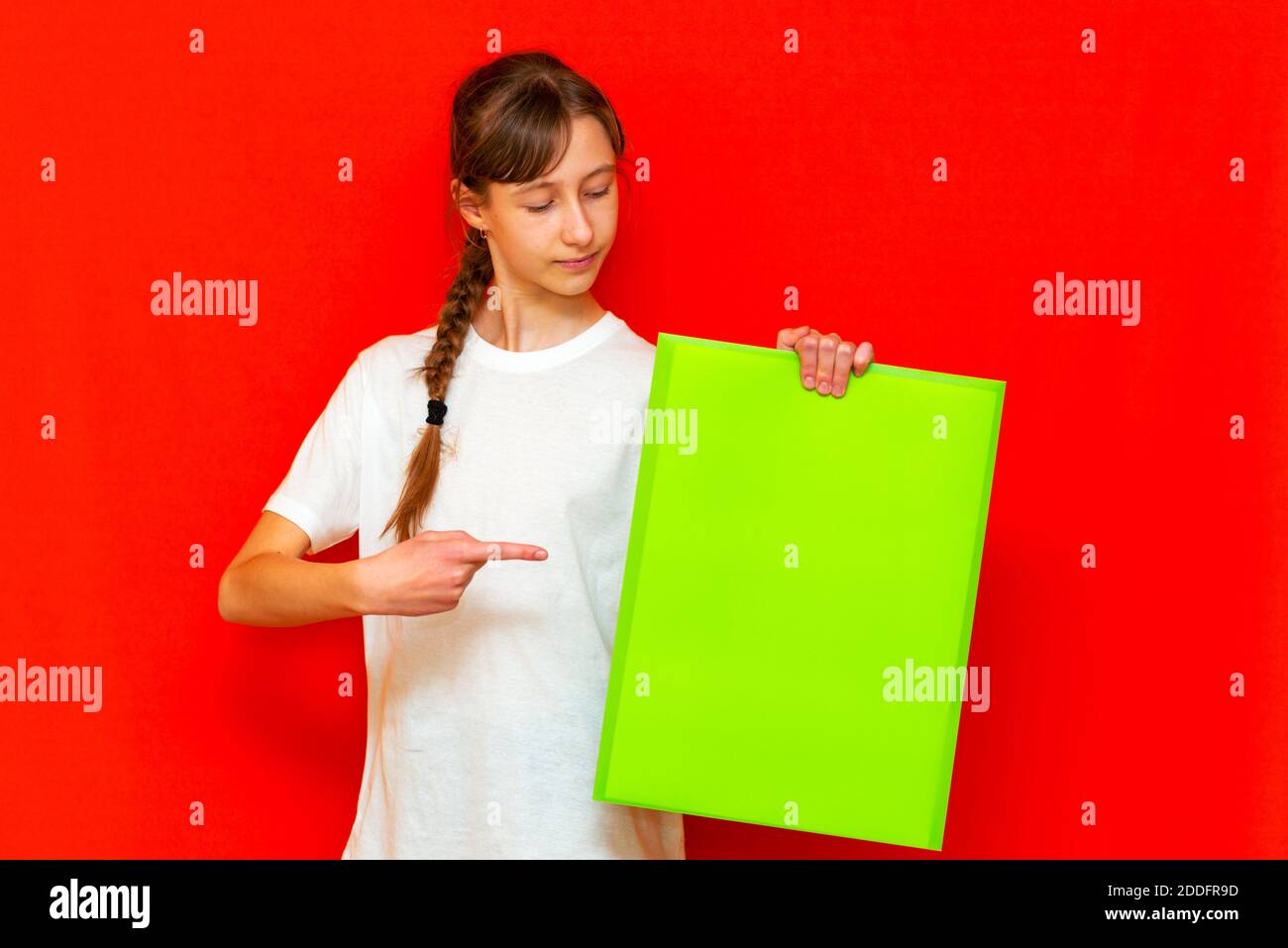Front view teenager girl showing blank paper.Mock up,banner,copy space ...