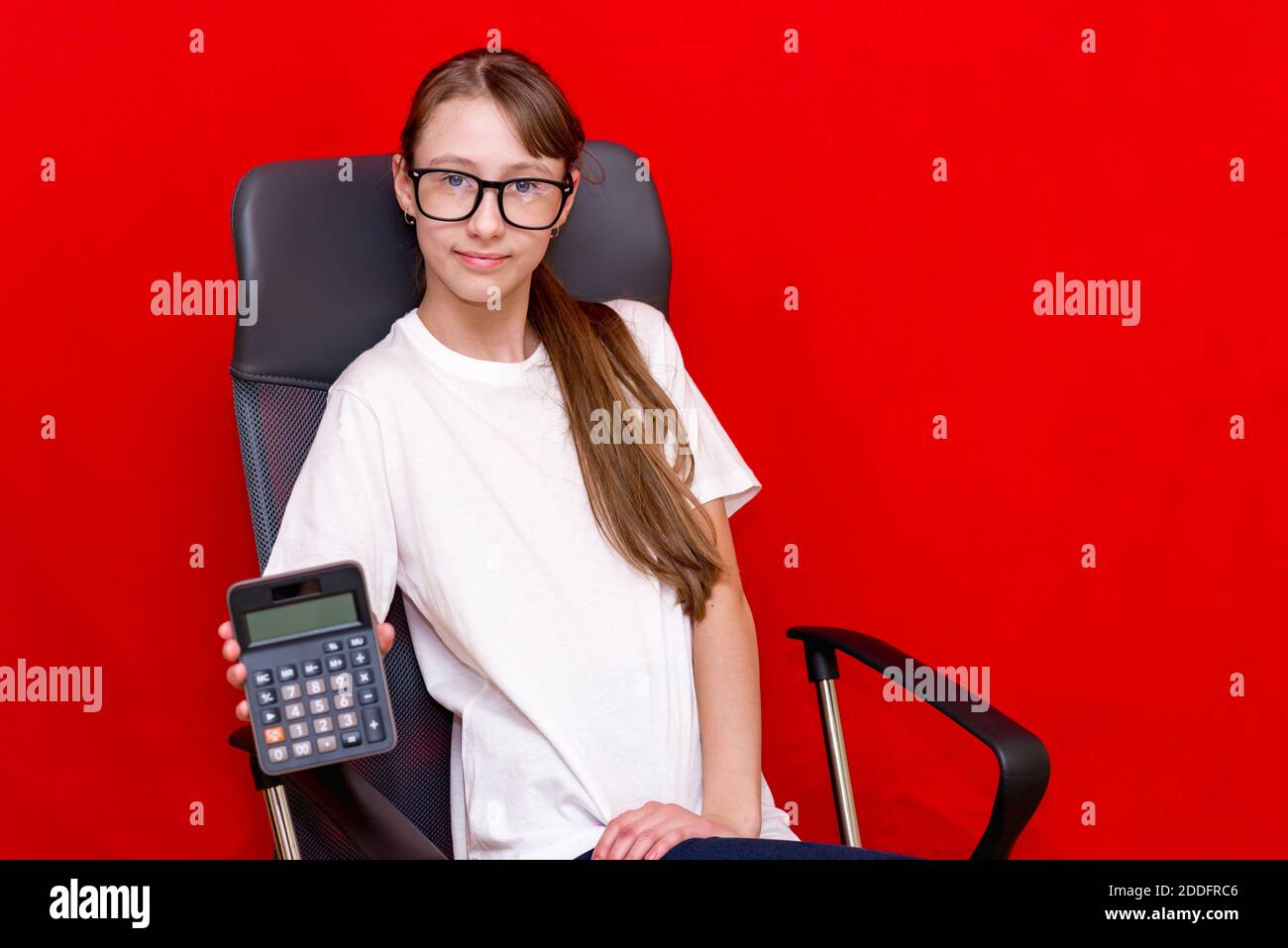 Young caucasian girl counting calculator. Education concept.Red studio ...