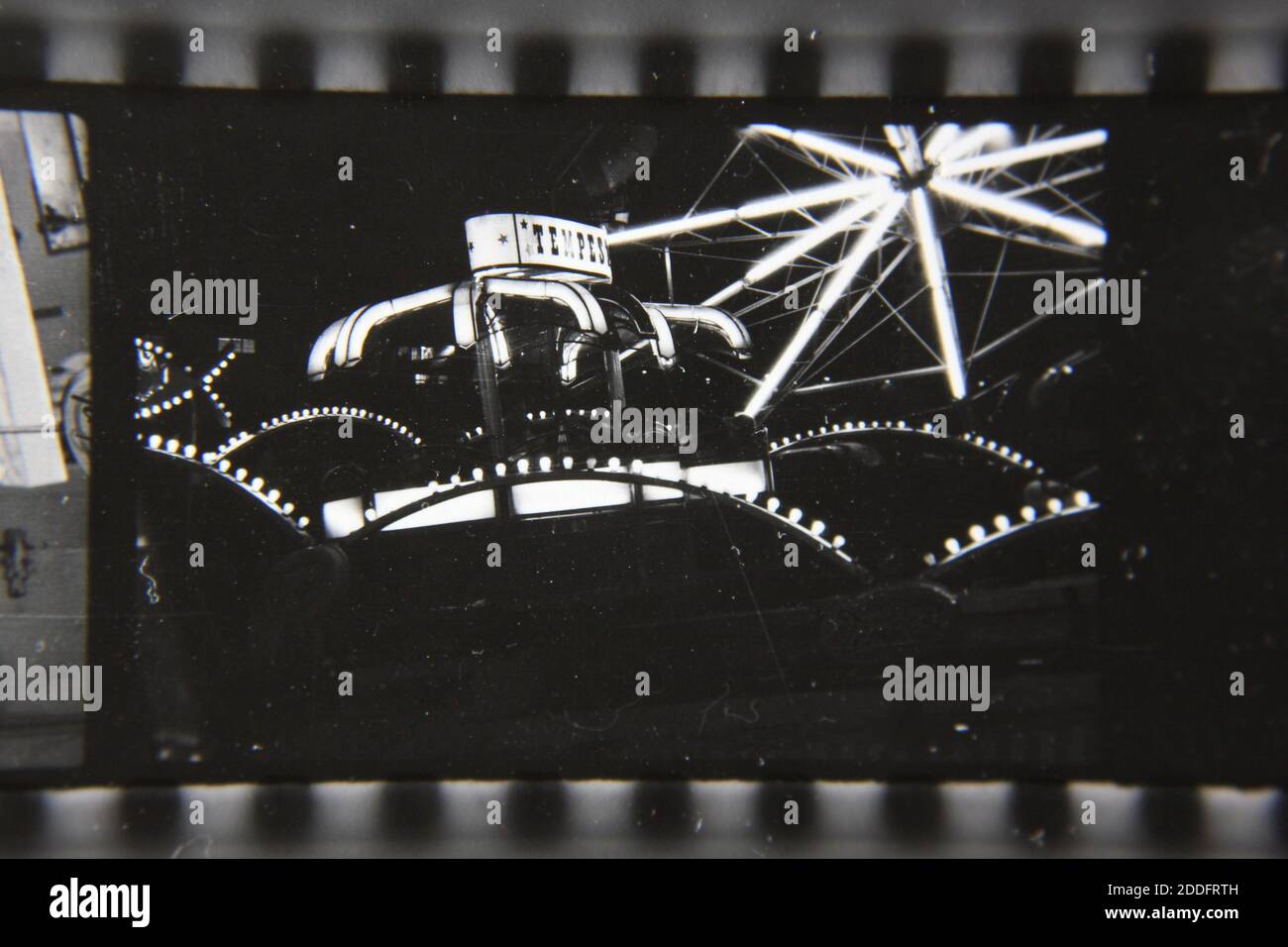 Fine 1970s vintage black and white photography of a carnival ride lit up at night with bright ...