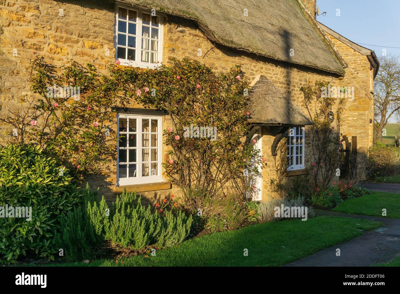 Winter sunshine falling on the honey coloured stone of a traditional ...