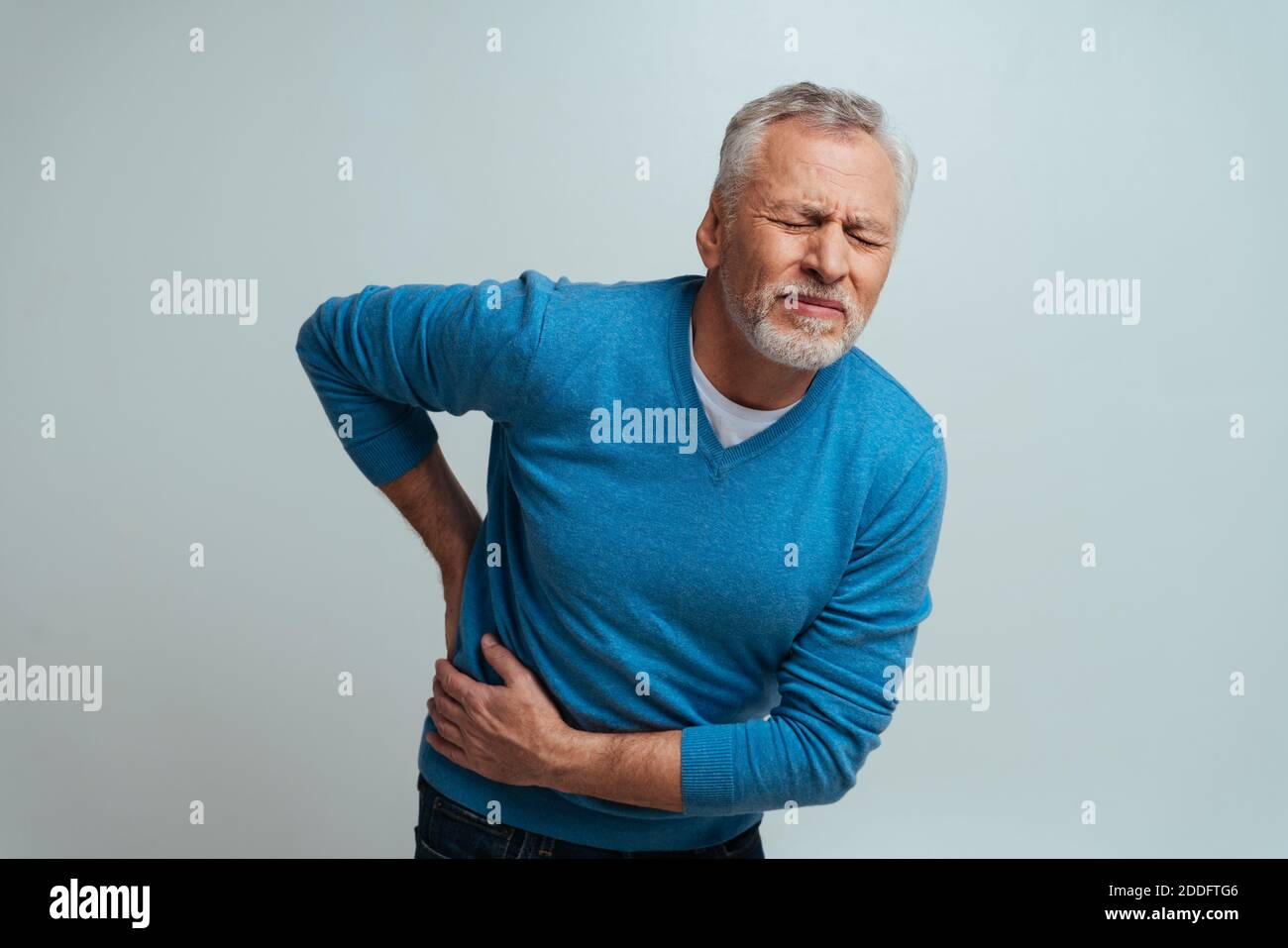 Handsome senior isolated on grey background. Old man feeling pain ...