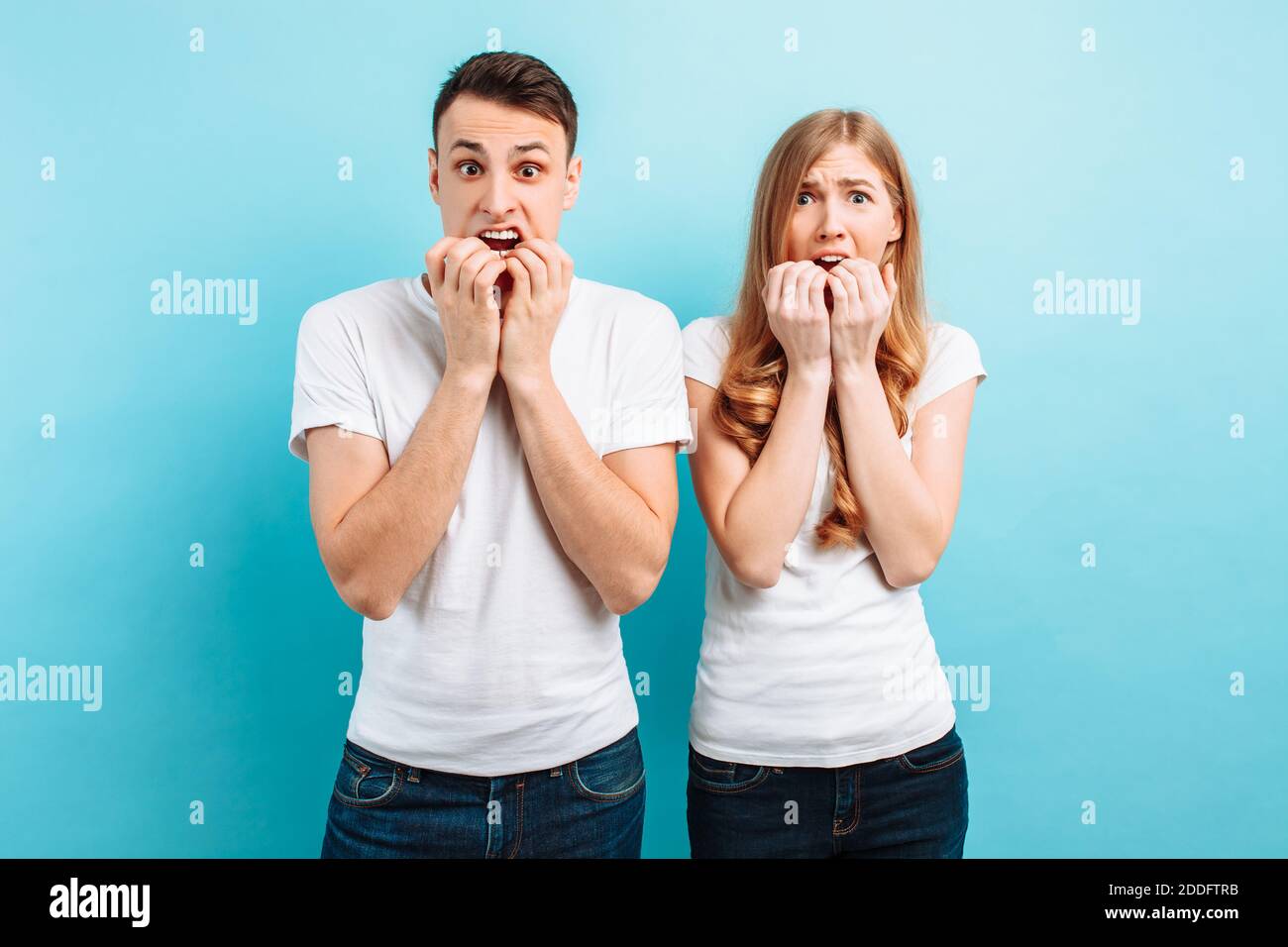 Image of a young couple, frightened man and woman, holding hands near ...