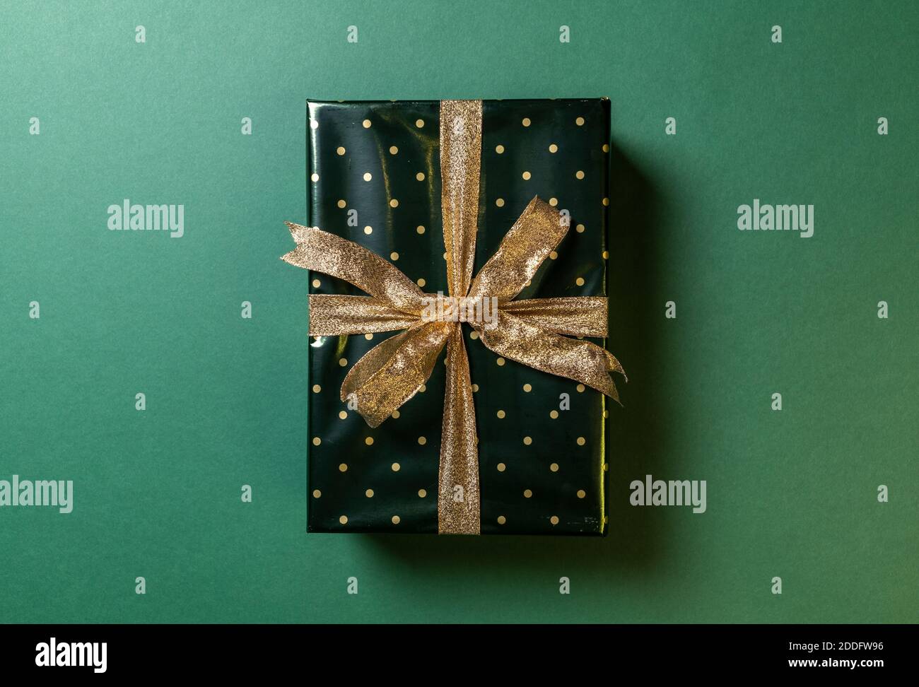one Christmas wrapped gift on green background Stock Photo - Alamy