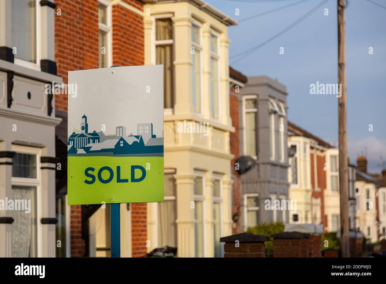 An estate agents sold sign outside a row of houses Stock Photo - Alamy
