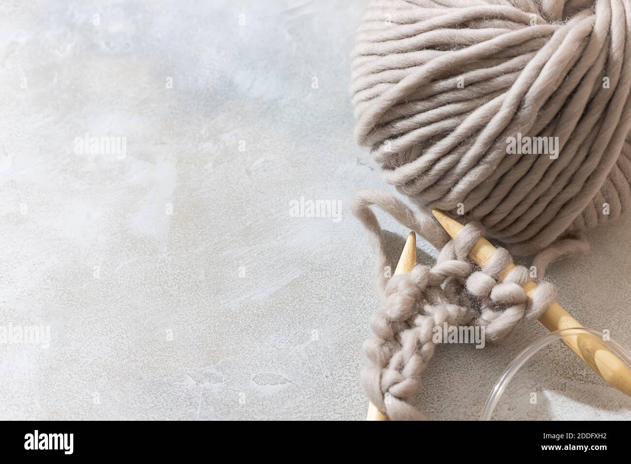 Female hands knitting with gray wool. Close up of knitting wooden ...