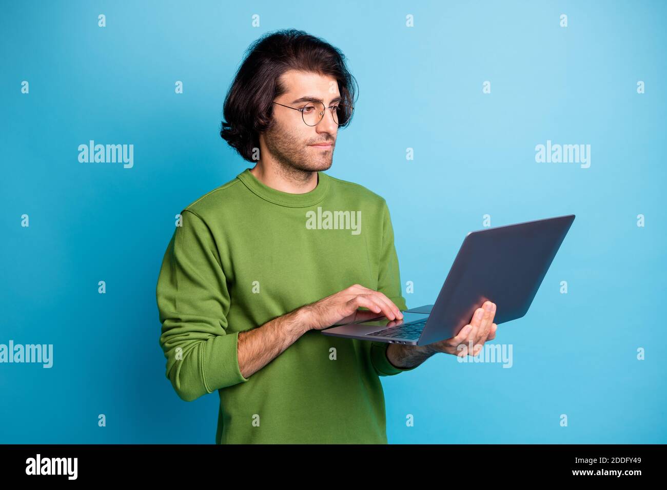 Photo of calm concentrated worker guy hold laptop look screen wear ...