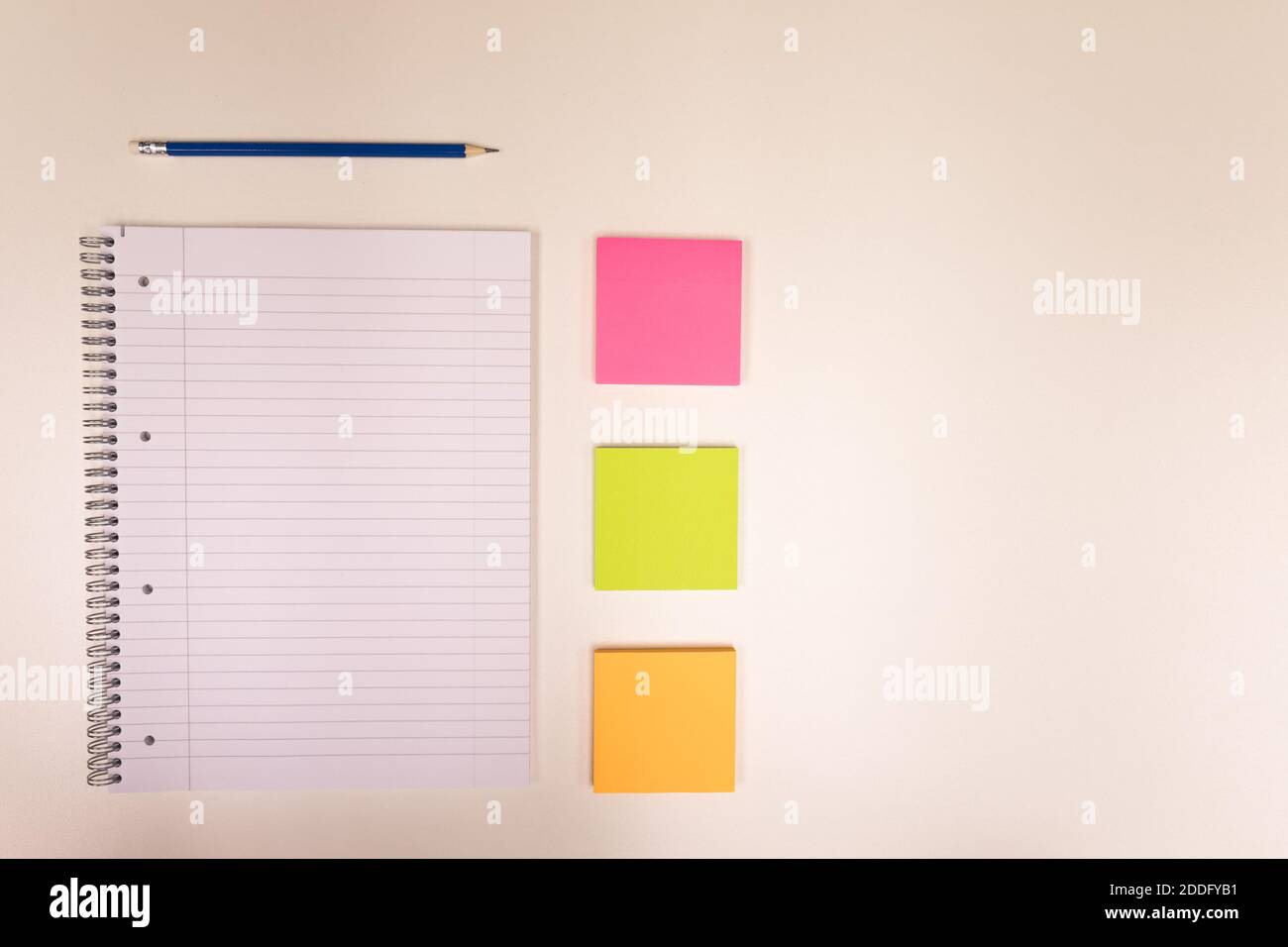 Notepad, pencil and small coloured note on a white desk Stock Photo - Alamy