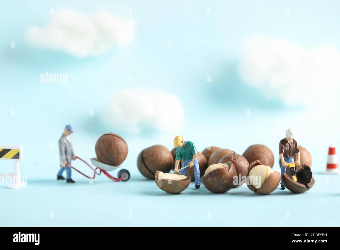 A closeup shot of mini construction worker figurines working on nuts ...