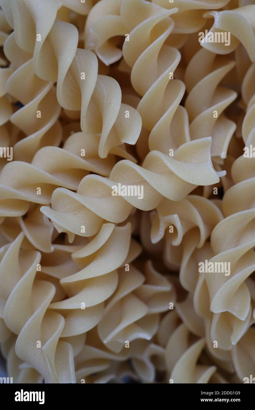 A top view closeup of uncooked swirling pasta piled up on each other ...
