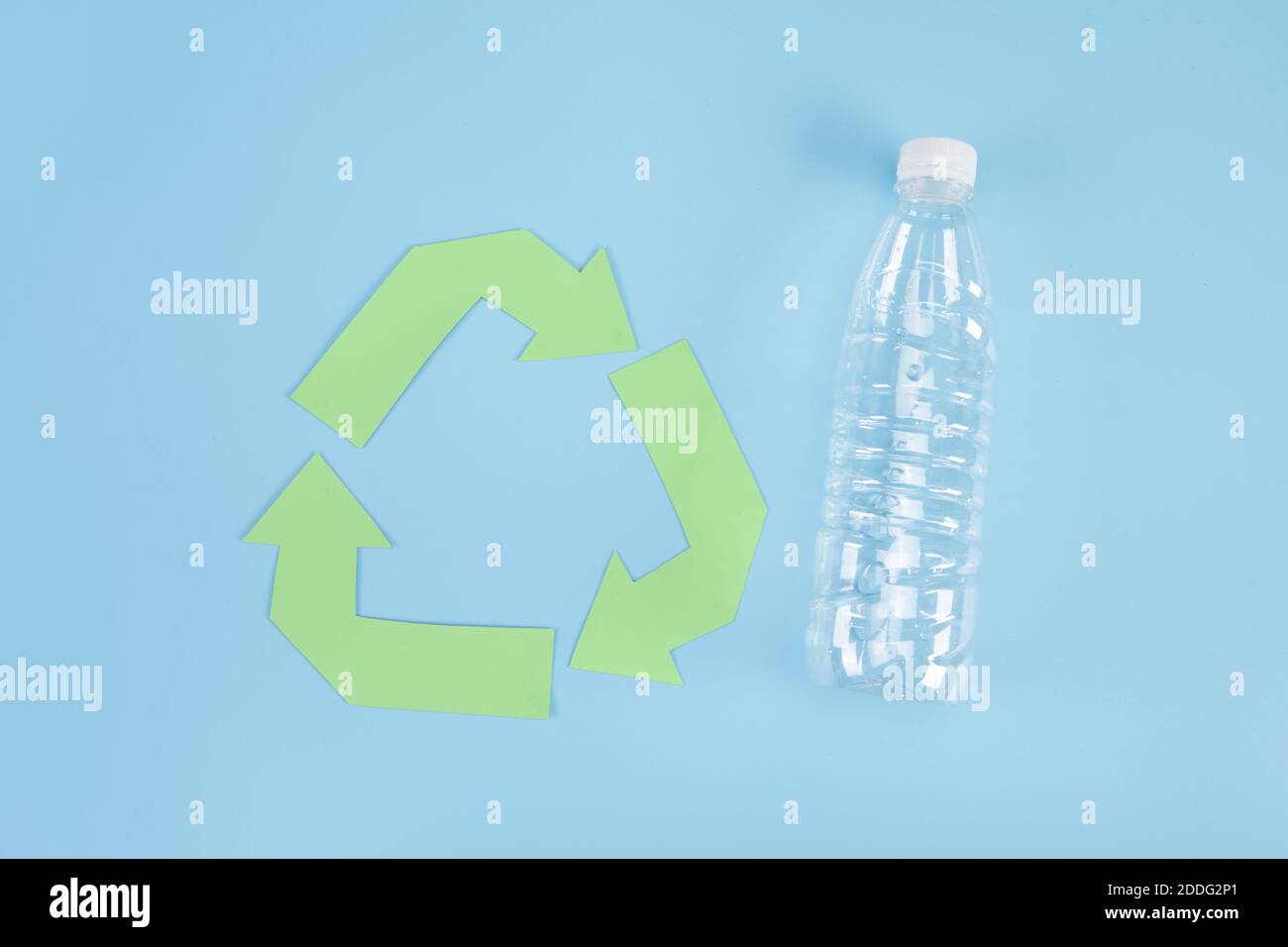 A top view of plastic bottle and recycling sign on blue surface ...