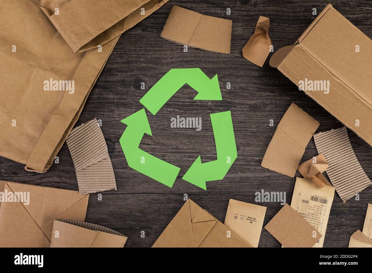 A top view of recycling sign and cardboard on wooden surface, recycling ...