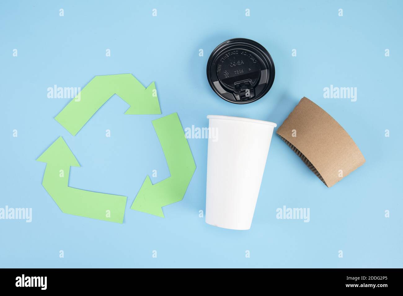 A top view of a paper cup and recycling sign on blue surface, recycling ...