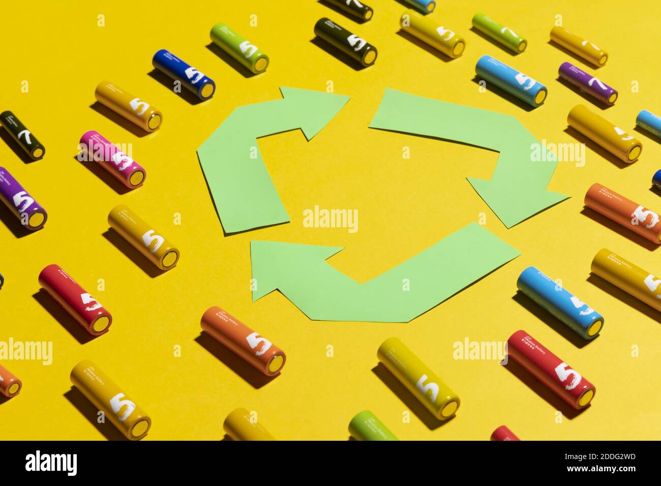 Recyclable sign and batteries on yellow background Stock Photo - Alamy
