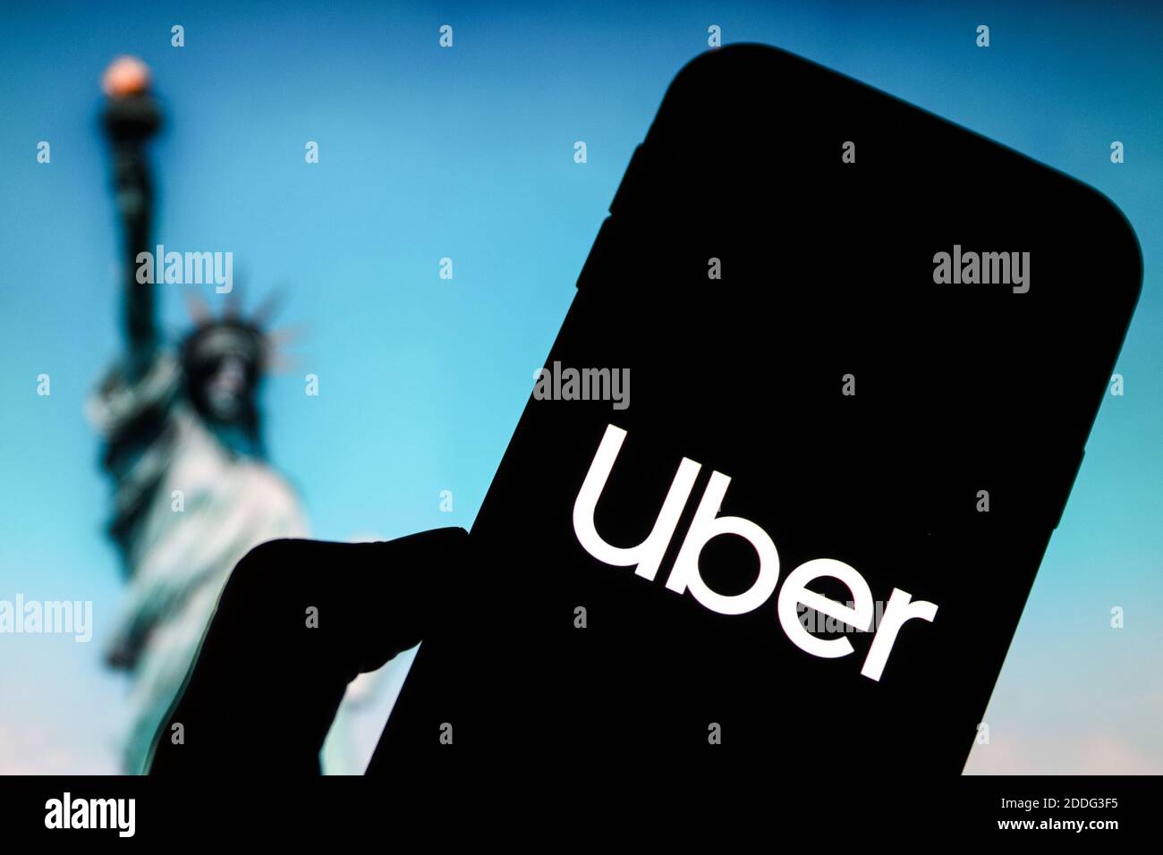 In this photo illustration a Uber company logo seen displayed on a ...