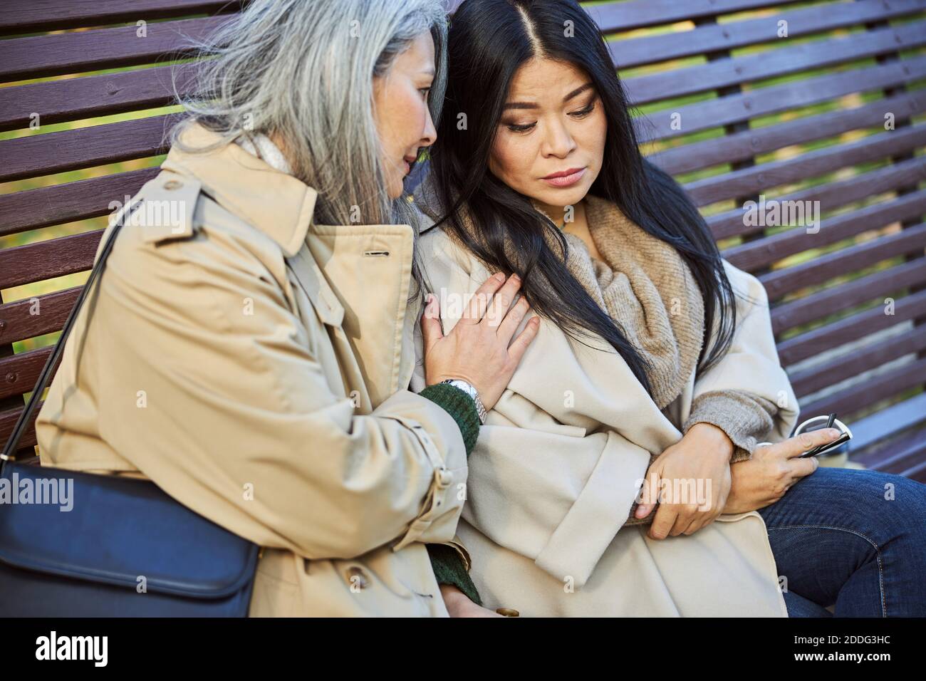 Caring woman comforting sad friend on the street Stock Photo - Alamy
