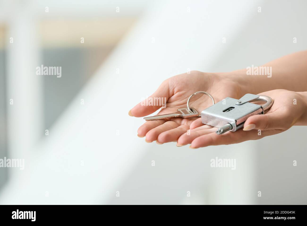 Female hands with key and padlock indoors Stock Photo - Alamy