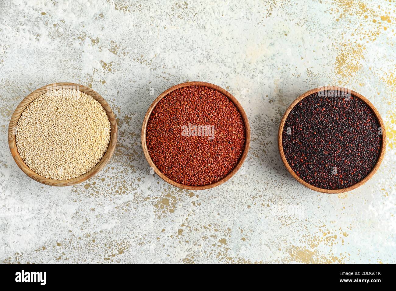 Bowls with different types of quinoa on light background Stock Photo ...
